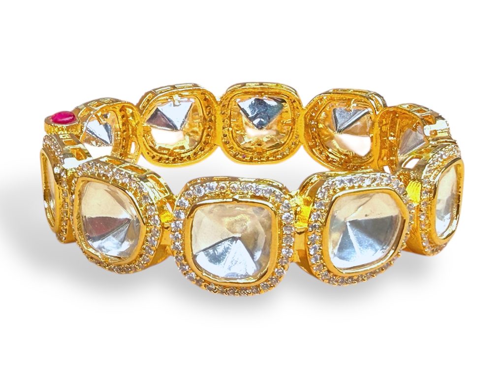 A Gold Plated Hinged Bangle Of Patterned Oval Panels, Each Inlaid With ...